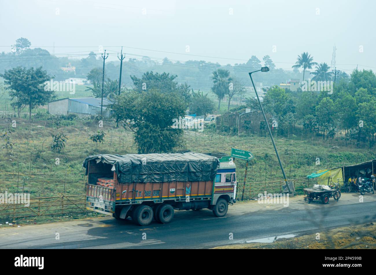 A running truck on a road against a scenic village view in the ...