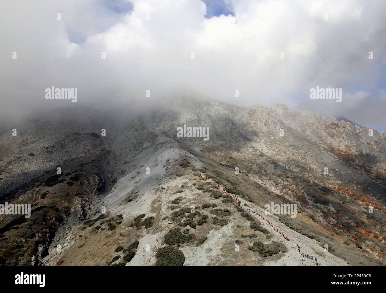 Rescuers, center, climb Mount Ontake covered by volcanic smoke and ...