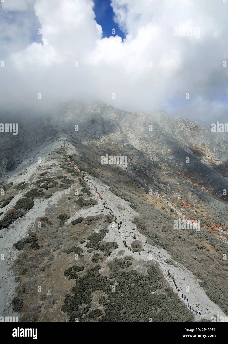 Rescuers, center, climb Mount Ontake covered by volcanic smoke and ...