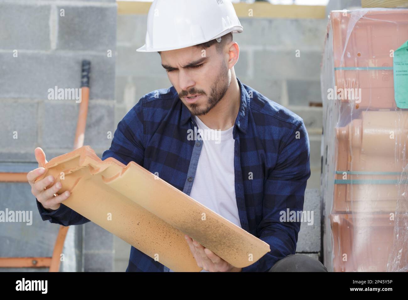 man in builder holding a tile Stock Photo - Alamy