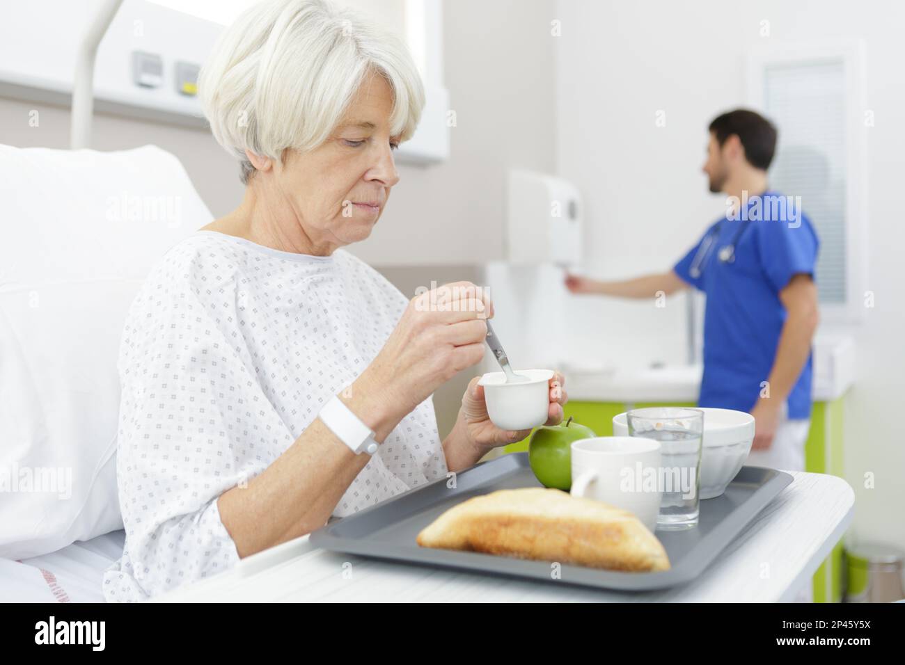 senior hospital patient eating her lunch on a tray Stock Photo - Alamy