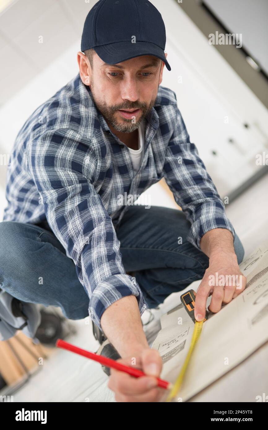 man measuring a floor tile Stock Photo - Alamy