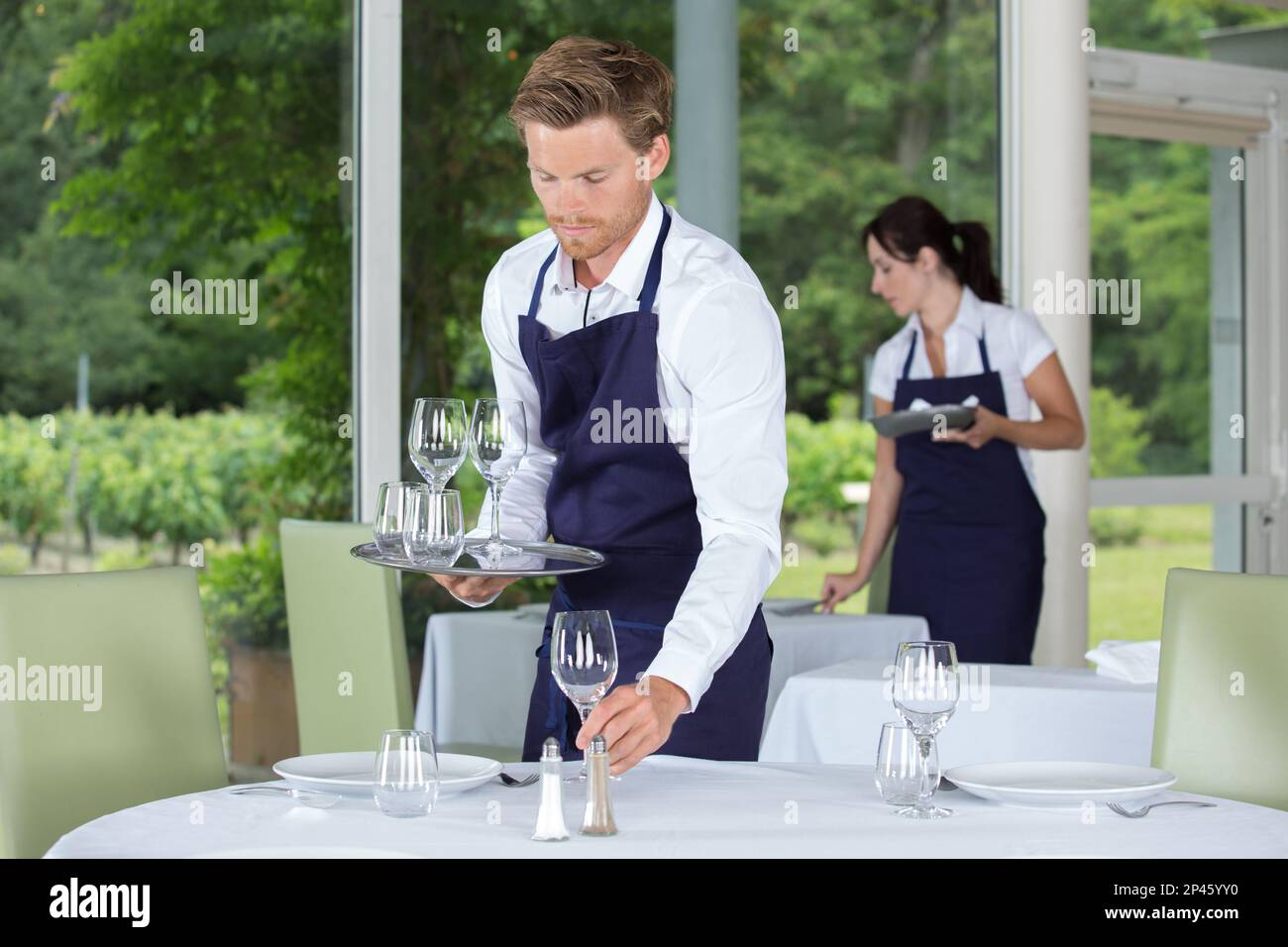 waiter setting the table in a fancy restaurant Stock Photo - Alamy
