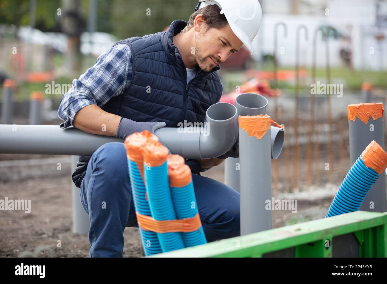 builder man installing pipes on construction site Stock Photo - Alamy