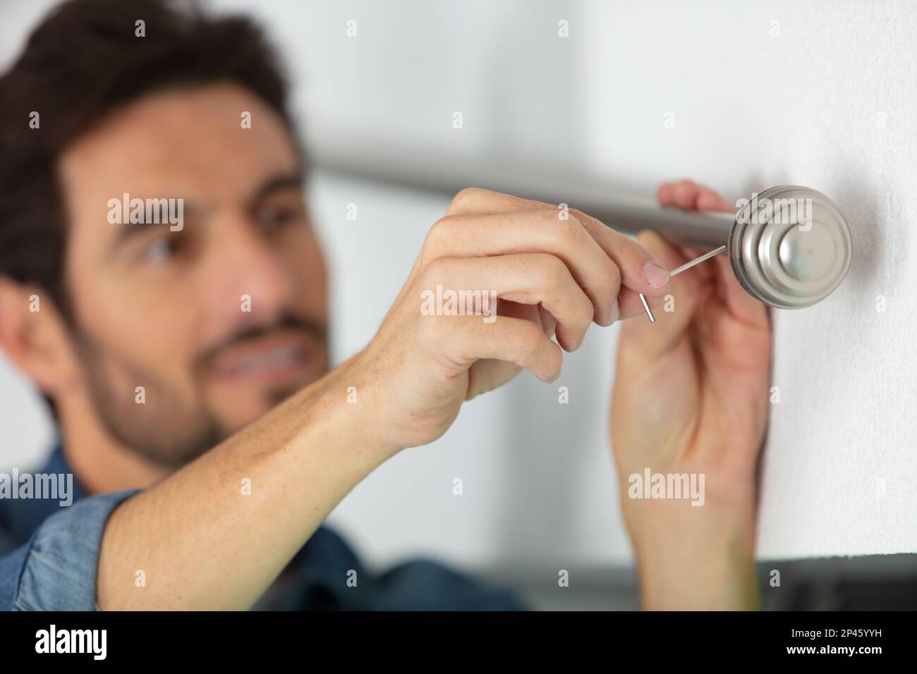 worker installing window curtain rod on the wall Stock Photo - Alamy