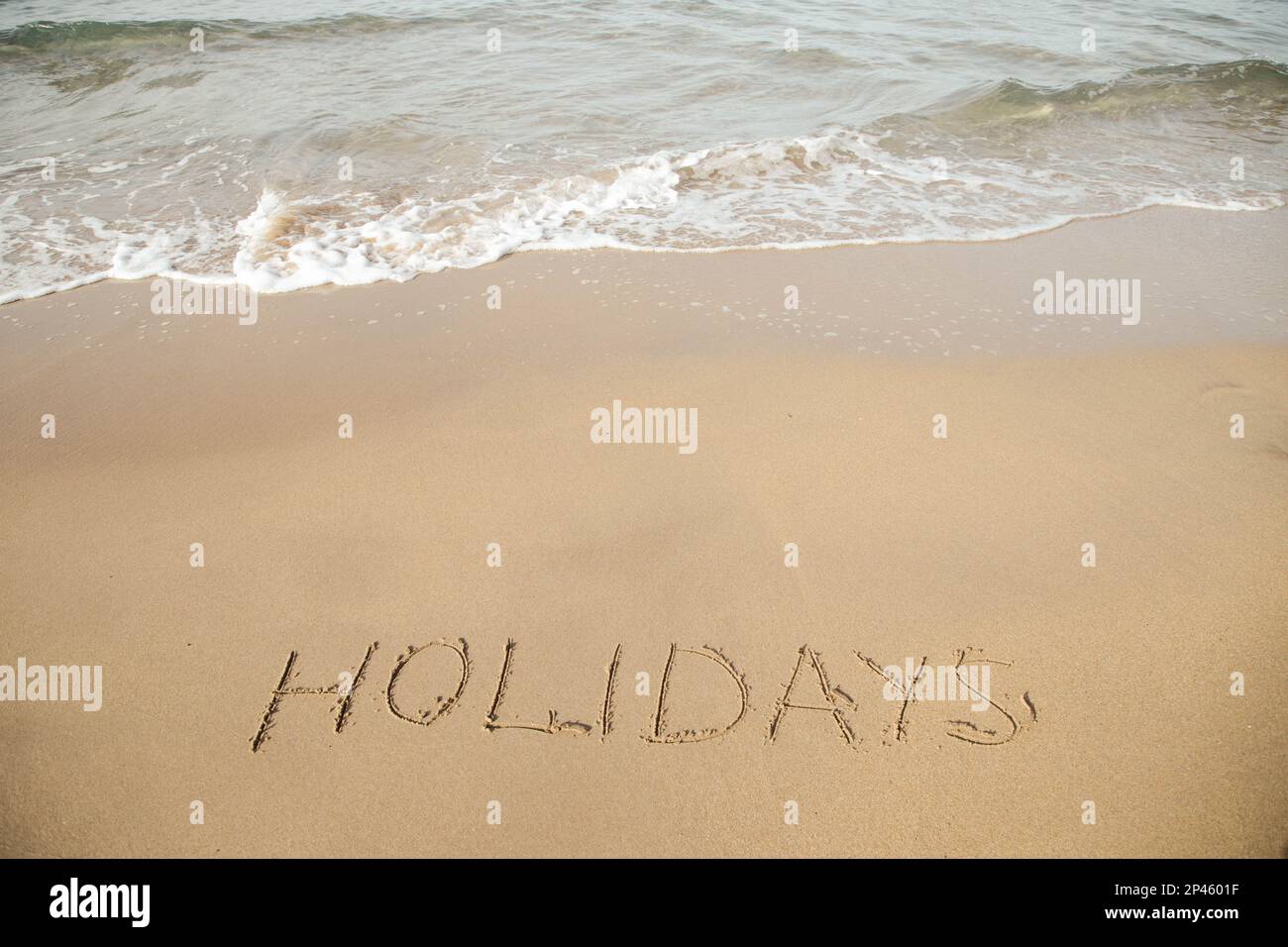 Holidays lettering on the beach with wave and clear blue sea Stock ...