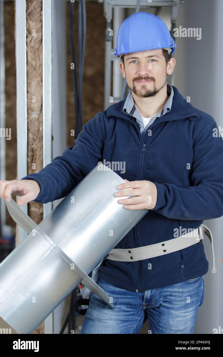 construction worker on site holding pipe Stock Photo - Alamy