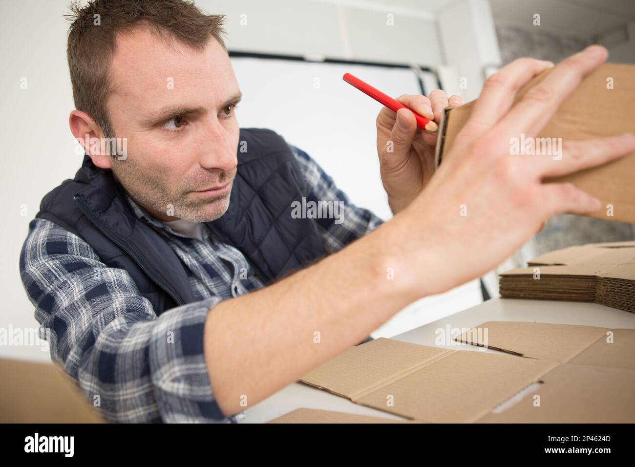 man writing on cardboard box Stock Photo - Alamy