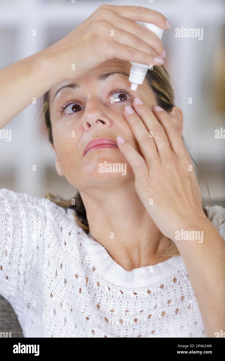 woman using eye drops in eyes Stock Photo - Alamy