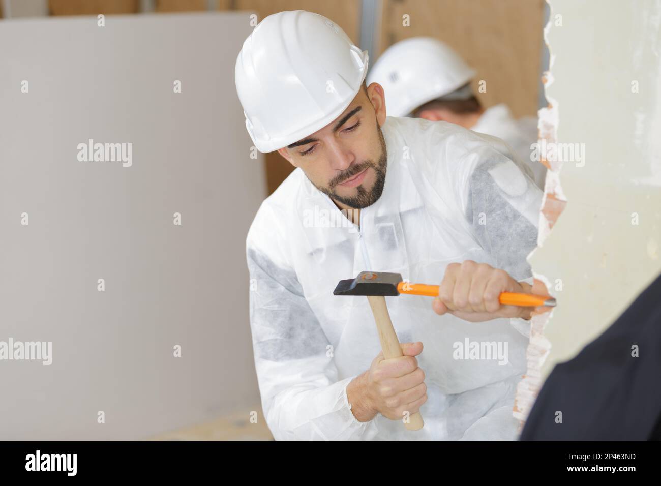 young male builder using hammer and chisel Stock Photo - Alamy