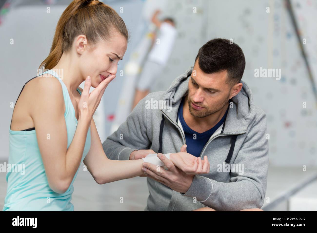 man helping young woman fell during climbing wall Stock Photo - Alamy