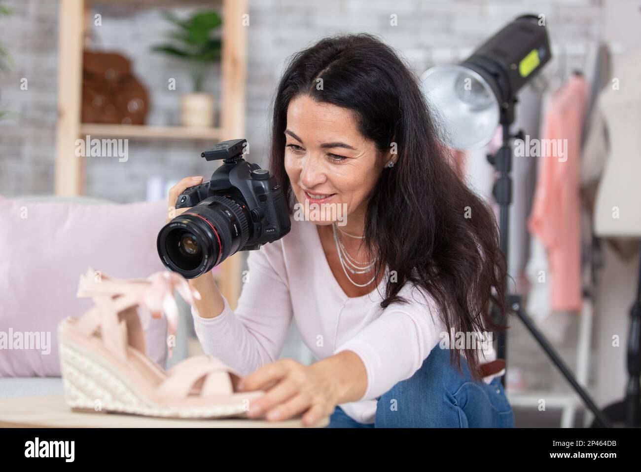 mature female photographer arranging shoes for a presentation shoot ...