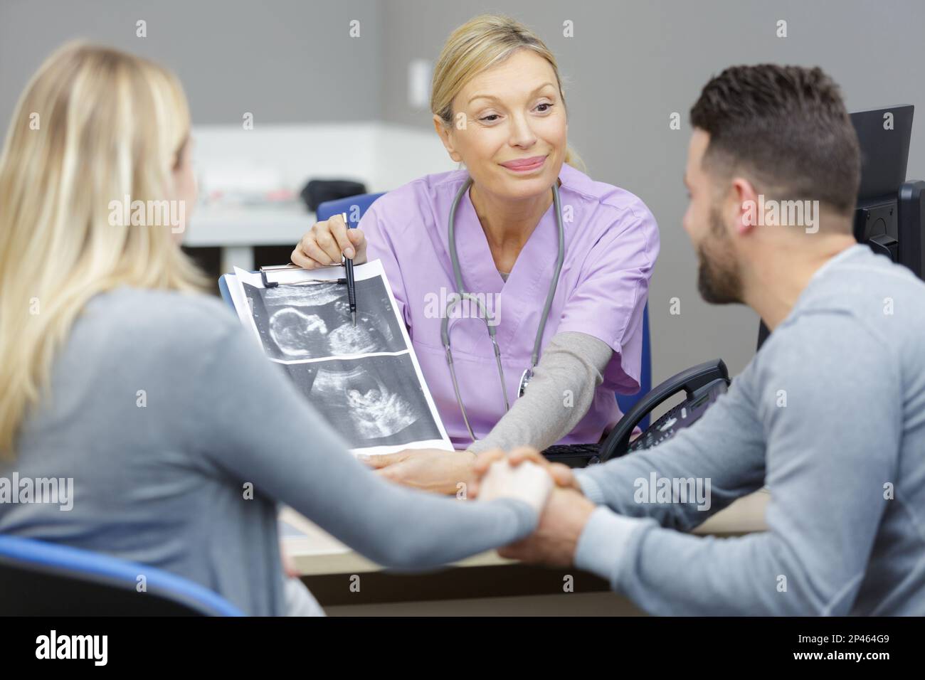 gynecologist showing couple the scans of the baby Stock Photo - Alamy