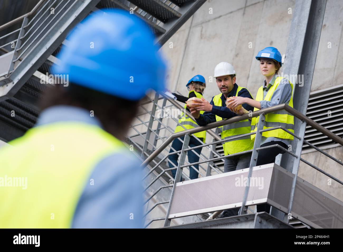 engineer standing on stair step talking with coworkers Stock Photo - Alamy
