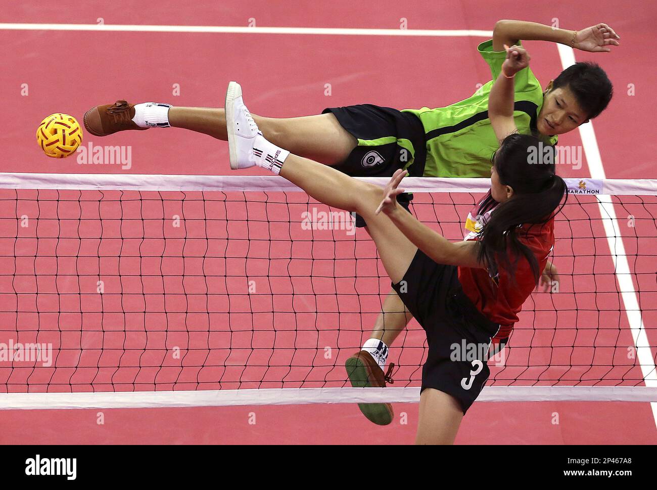 Myanmar's Phyu Phyu Than, top, kicks a ball as Laos player Koy Xayavong ...