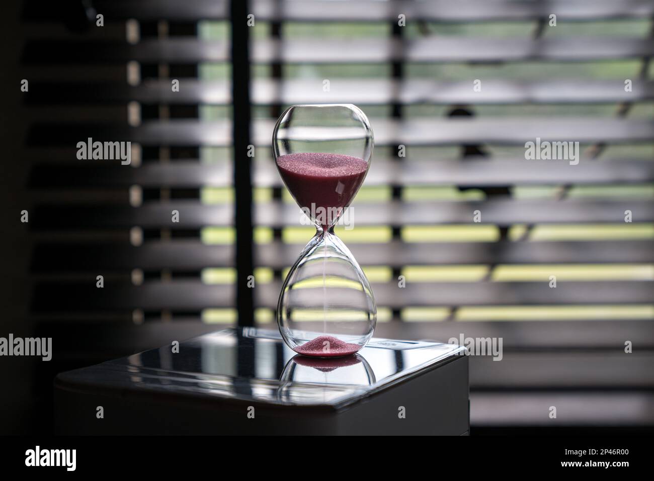 Sand running or flowing down of an hourglass measuring the passing of ...