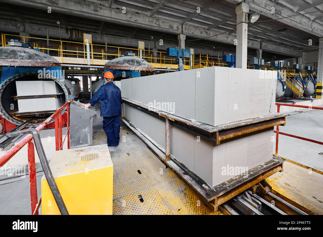 Worker controls concrete blocks outputting out of digester Stock Photo ...