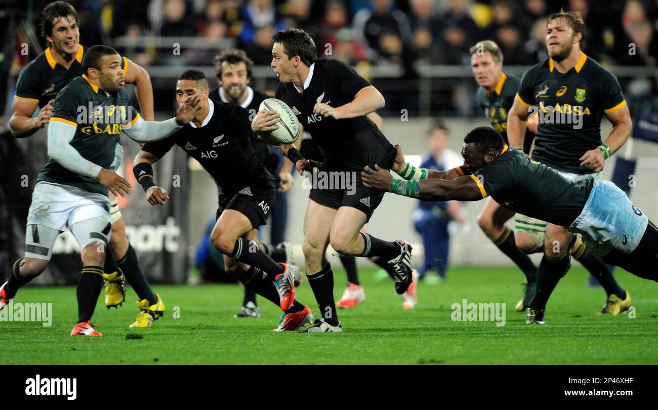 New Zealand’s Ben Smith, center, runs from the grip of South Africa’s ...