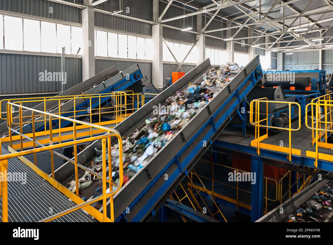 Conveyors carry trash and empty platforms at recycling plant Stock Photo - Alamy