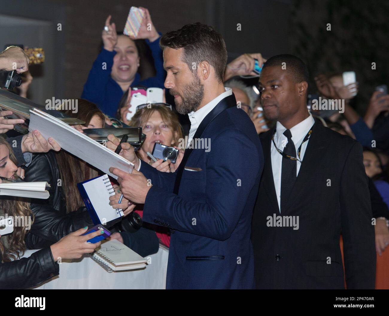 Actor Ryan Reynolds signs autographs on the red carpet for the new ...