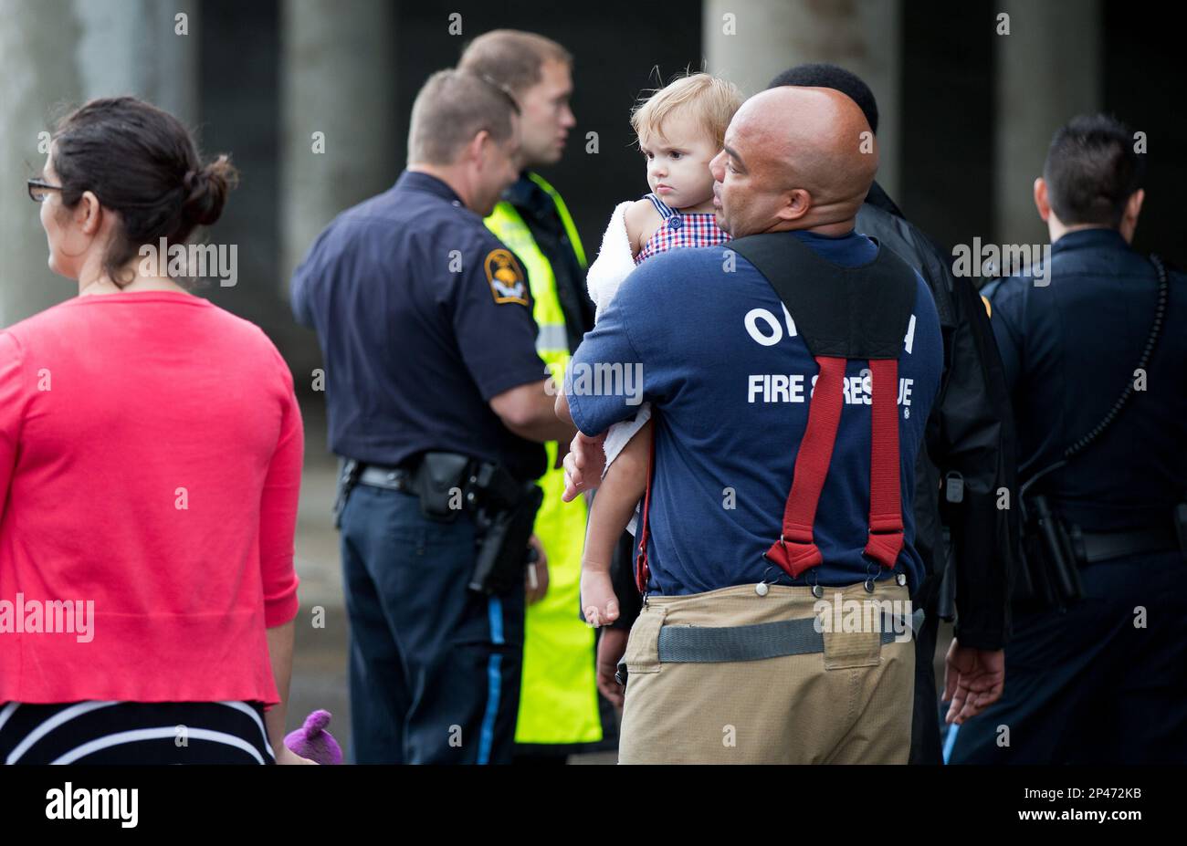 Omaha firefighter Chris Draft of Engine 42 holds the youngest of three ...