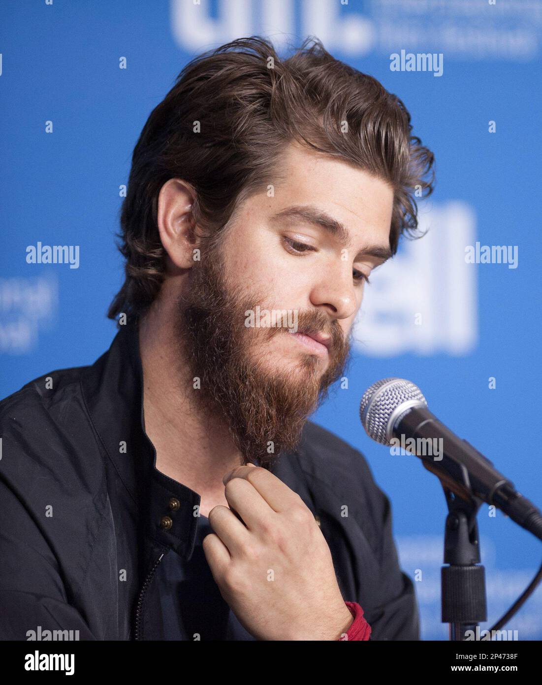 Actor Andrew Garfield pulls his beard during a press conference for "99 ...