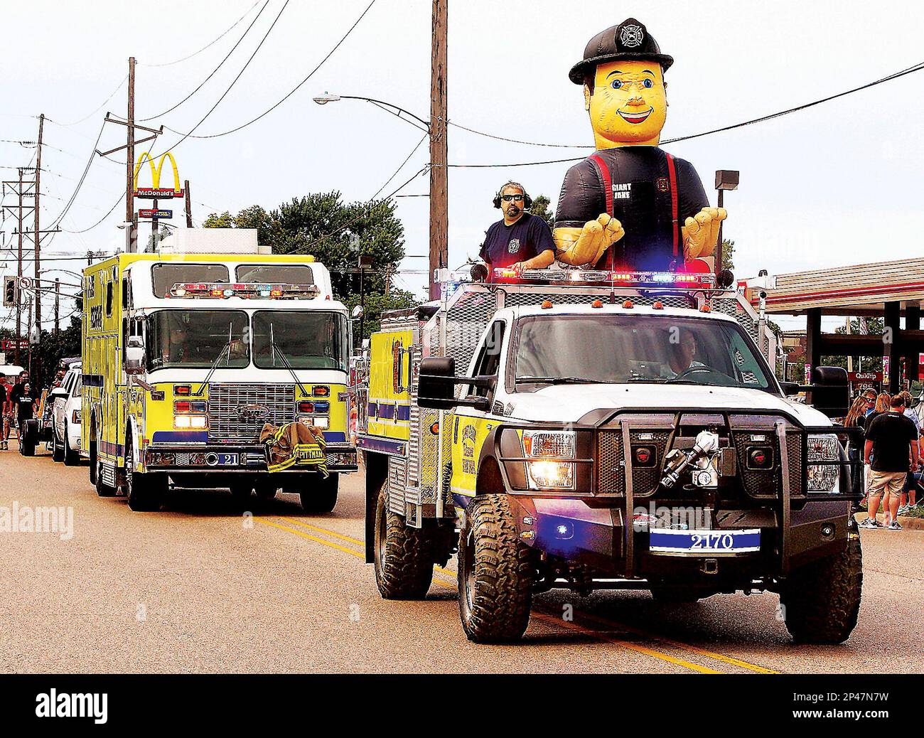 Giant Jake, an inflatable firefighter, rides atop a fire truck from the ...