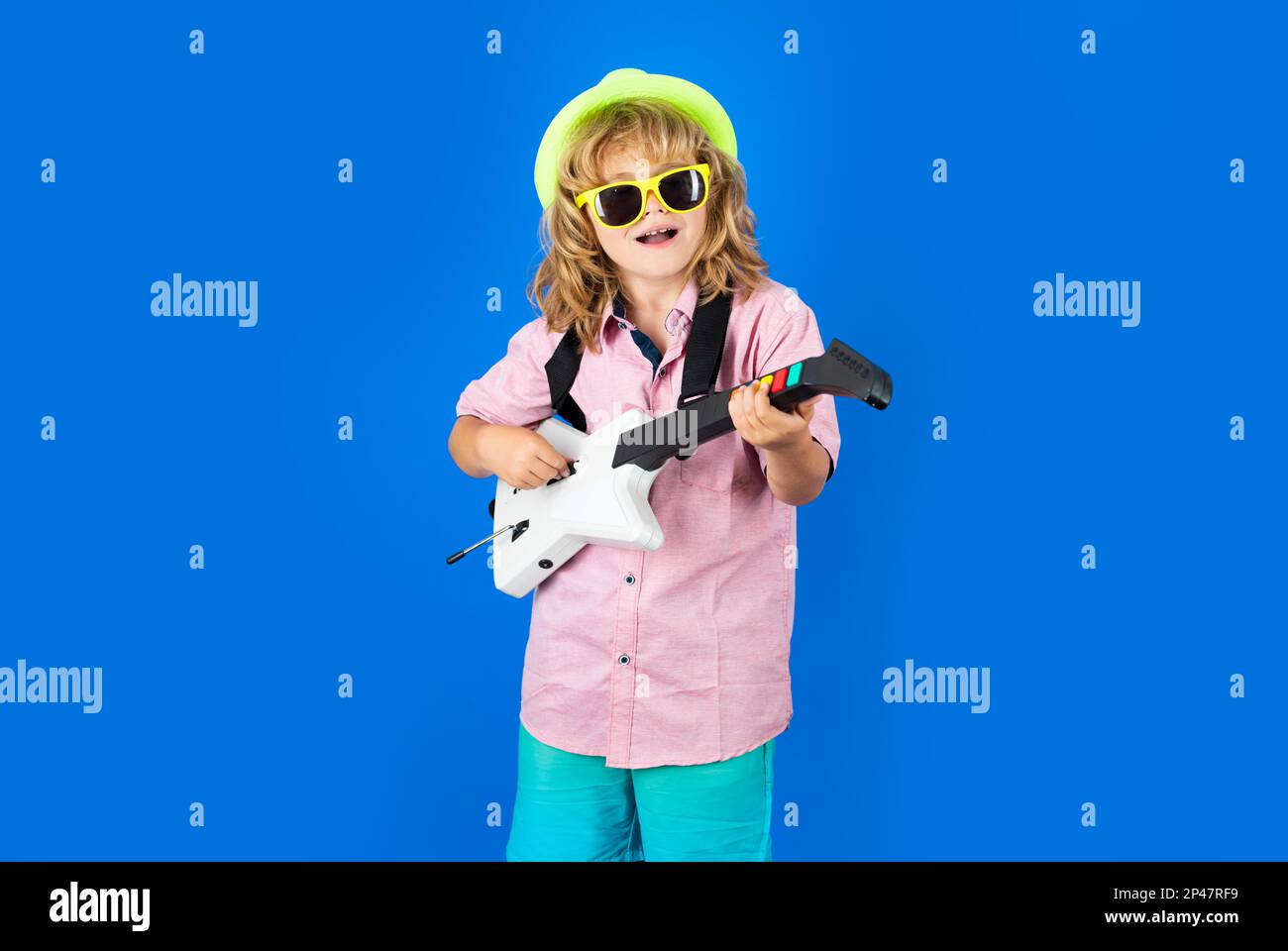 Cute child boy sings and plays on the electric guitar with bright ...