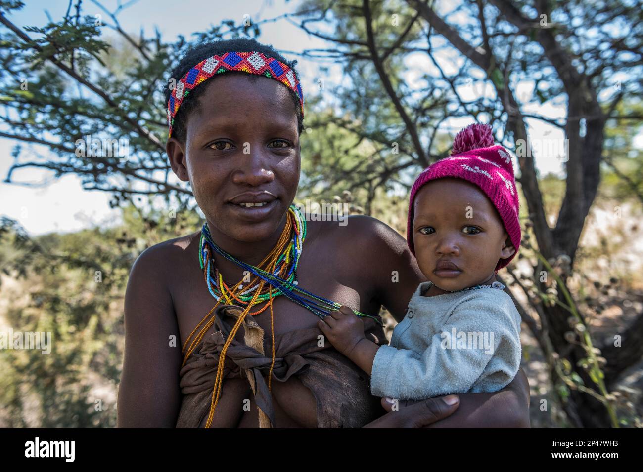 Africa, Botswana, Kalahari desert. Portrait of a woman and her baby who ...