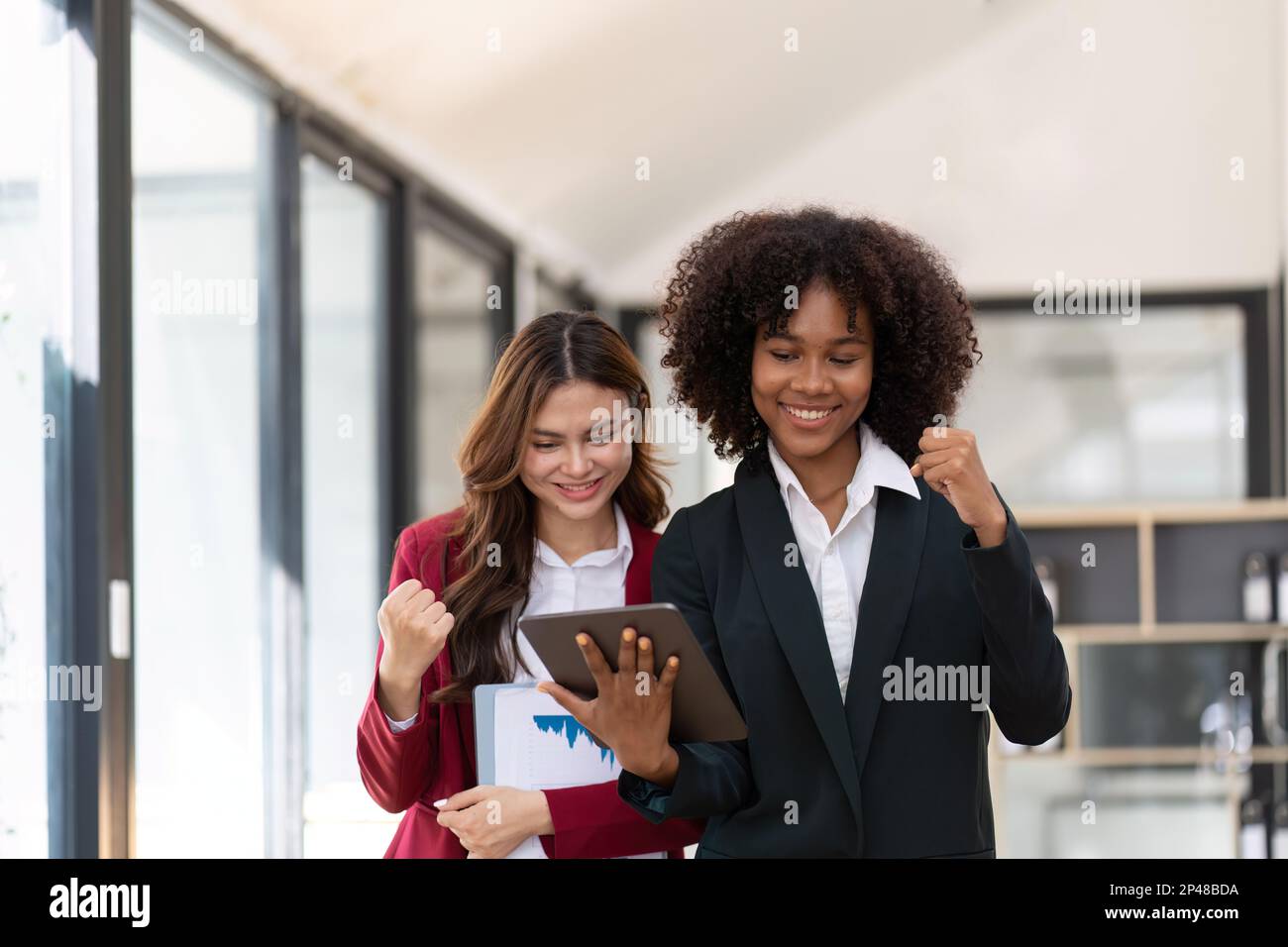Happy business people celebrate success looking at digital tablet ...