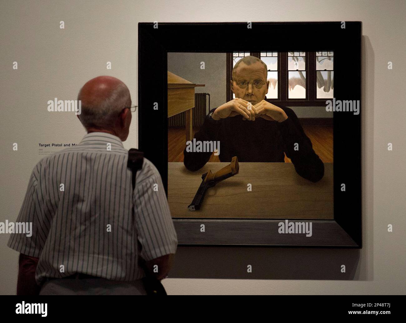A man looks the painting "Target Pistol and Man" by Alex Colville ...
