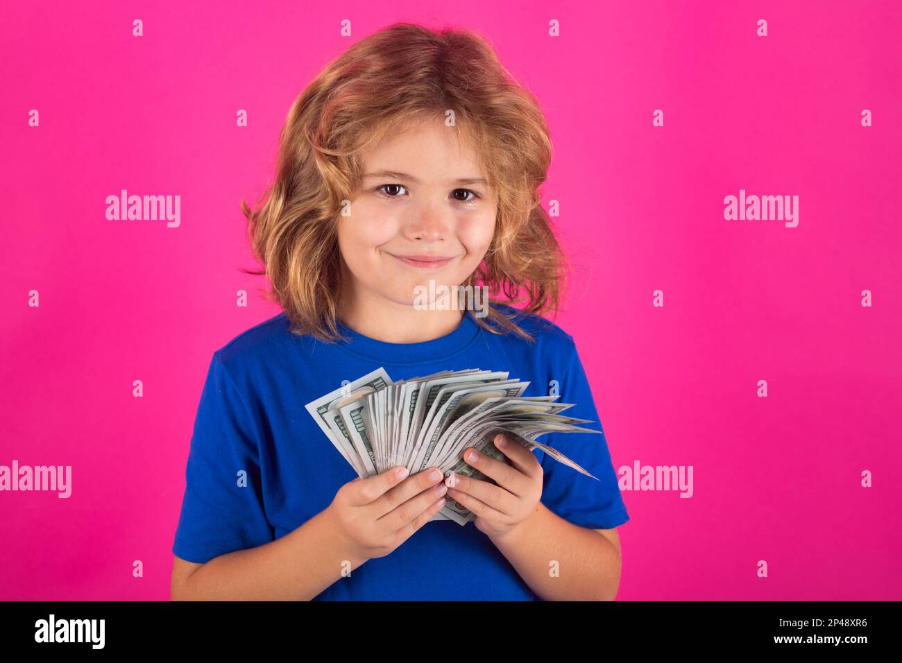 Portrait of a child with money dollars banknotes isolated over studio ...