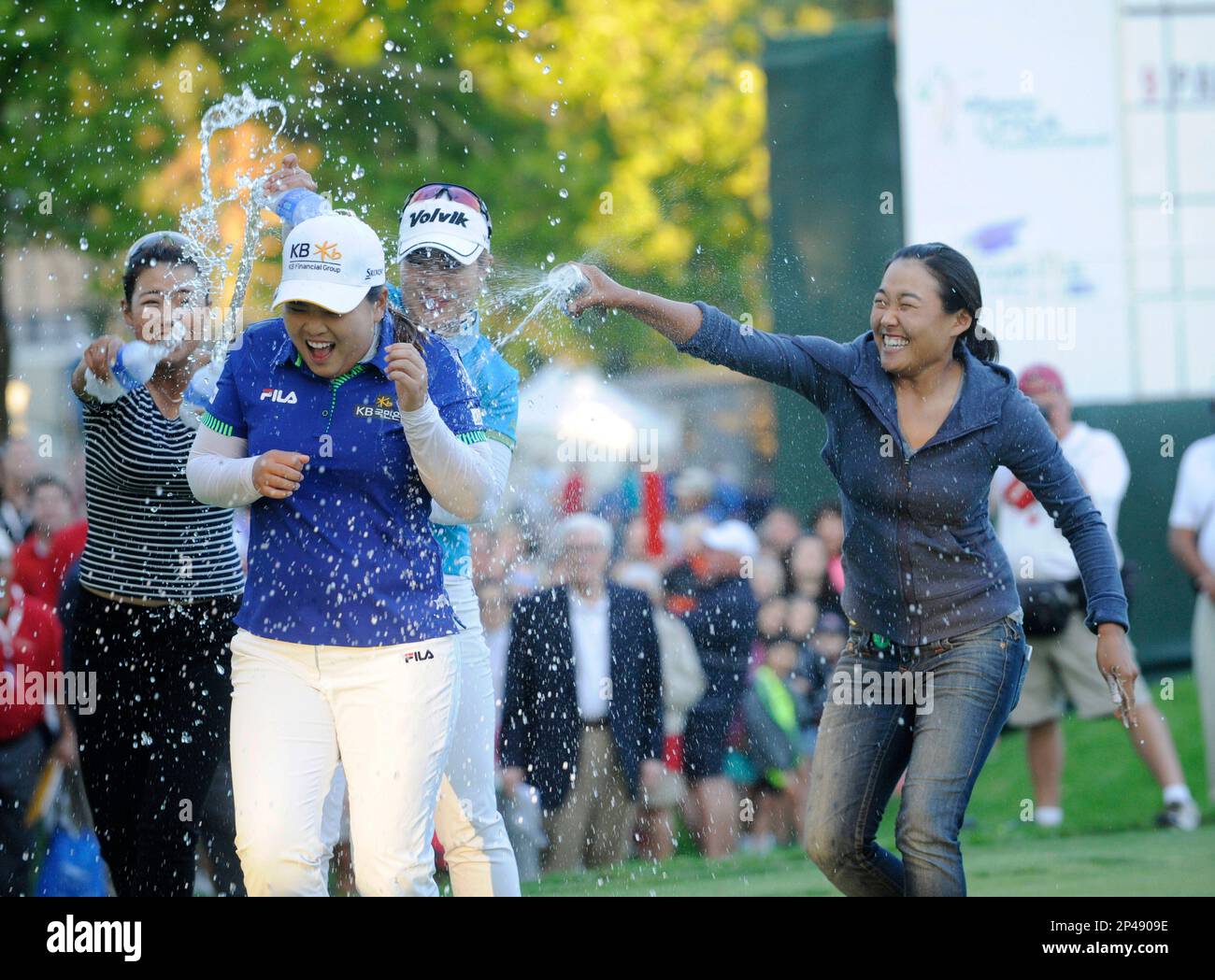 Jenny Shin, left, Meena Lee, center, and Illhee Lee, right, spray ...