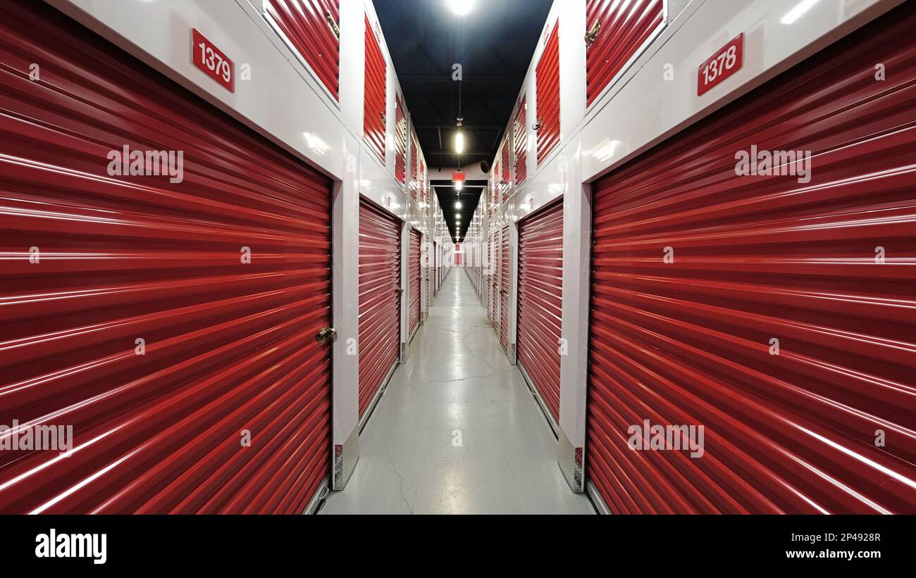Wide angle view of warehouse corridor with rows of self storage units ...