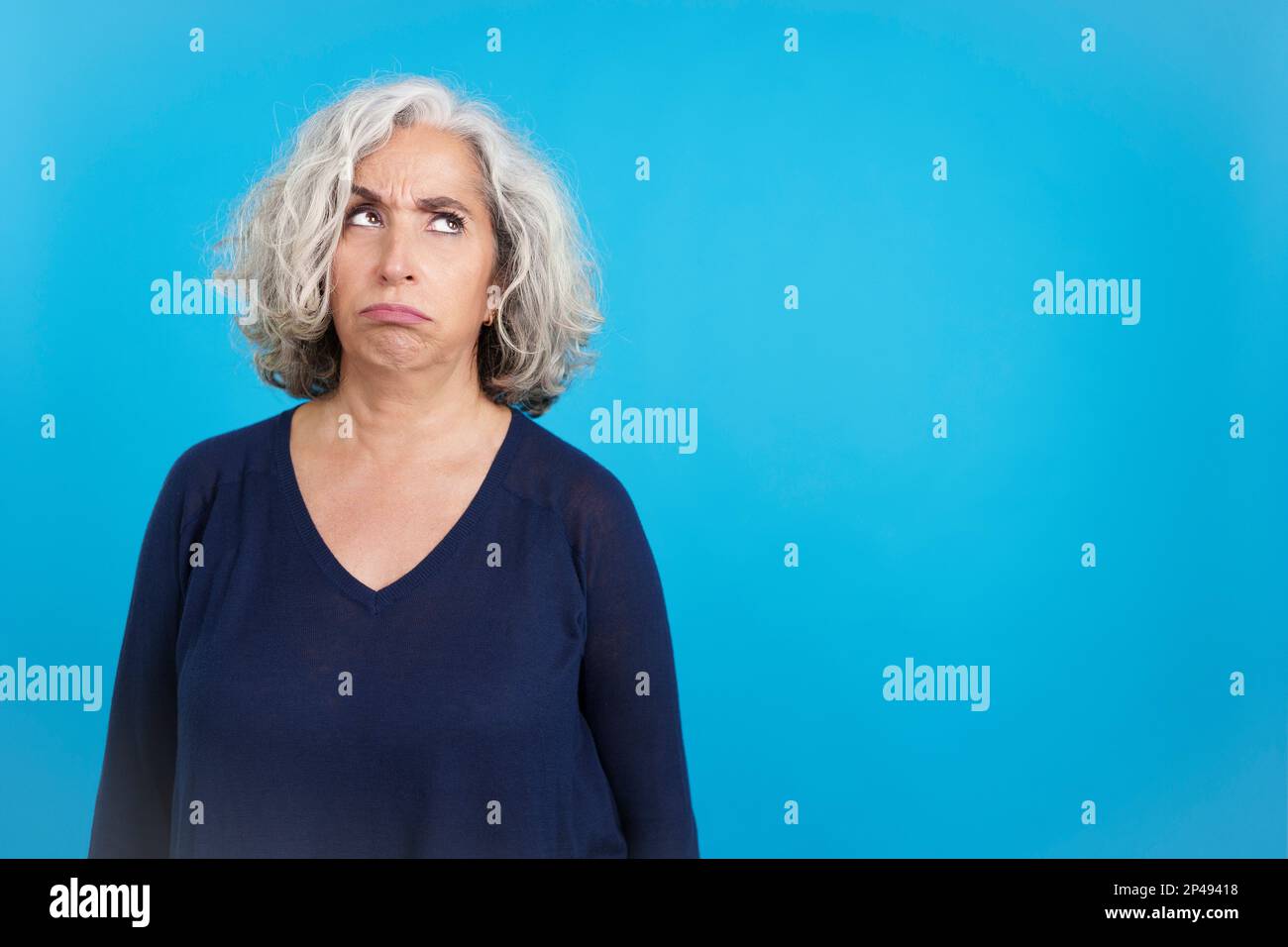 Mature woman looking up with an expression of discontent Stock Photo ...