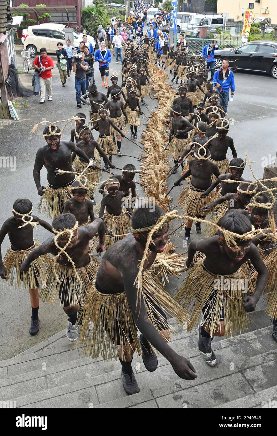 Children, wearing a straw-demons style, walk around the streets drawing ...