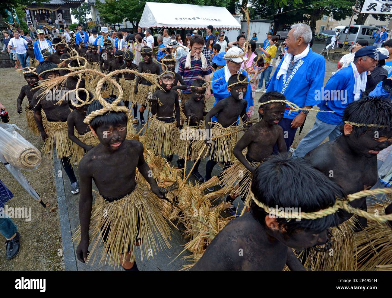 Children, wearing a straw-demons style, walk around the streets drawing ...