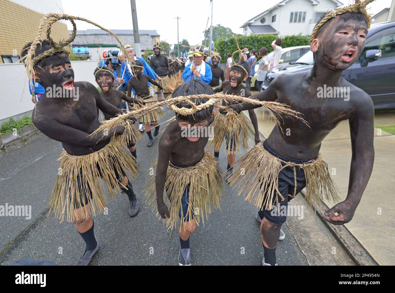 Children, wearing a straw-demons style, walk around the streets drawing ...