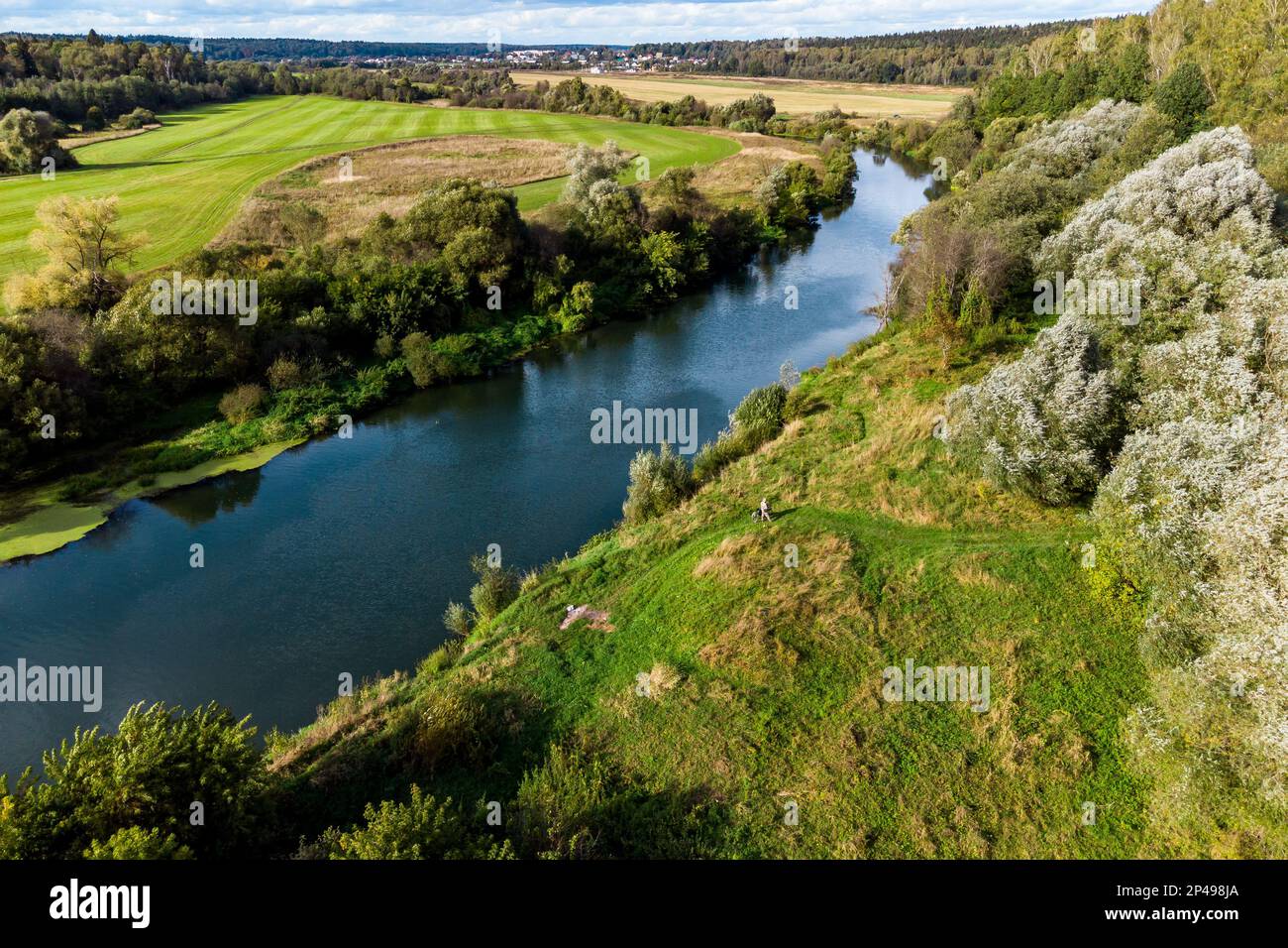 Aerial view of a landscape with a river flowing between fields and ...