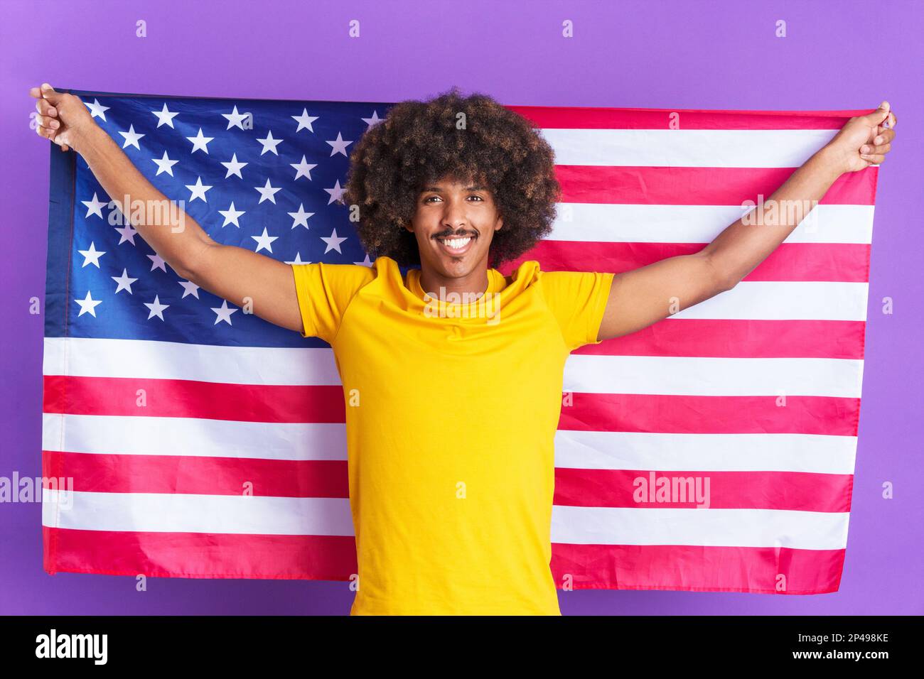 Happy african man raising a north america national flag Stock Photo - Alamy