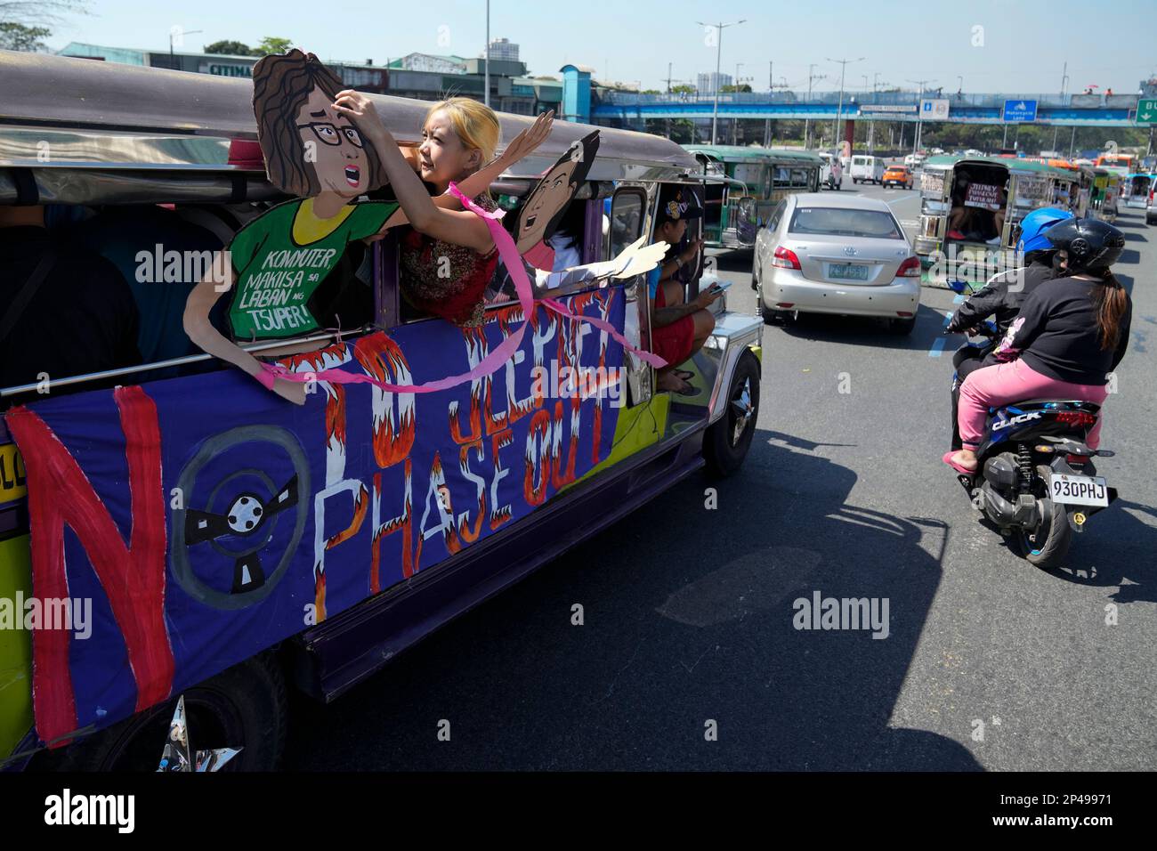 An activist arranges a slogan on a passenger jeepney during a transport ...