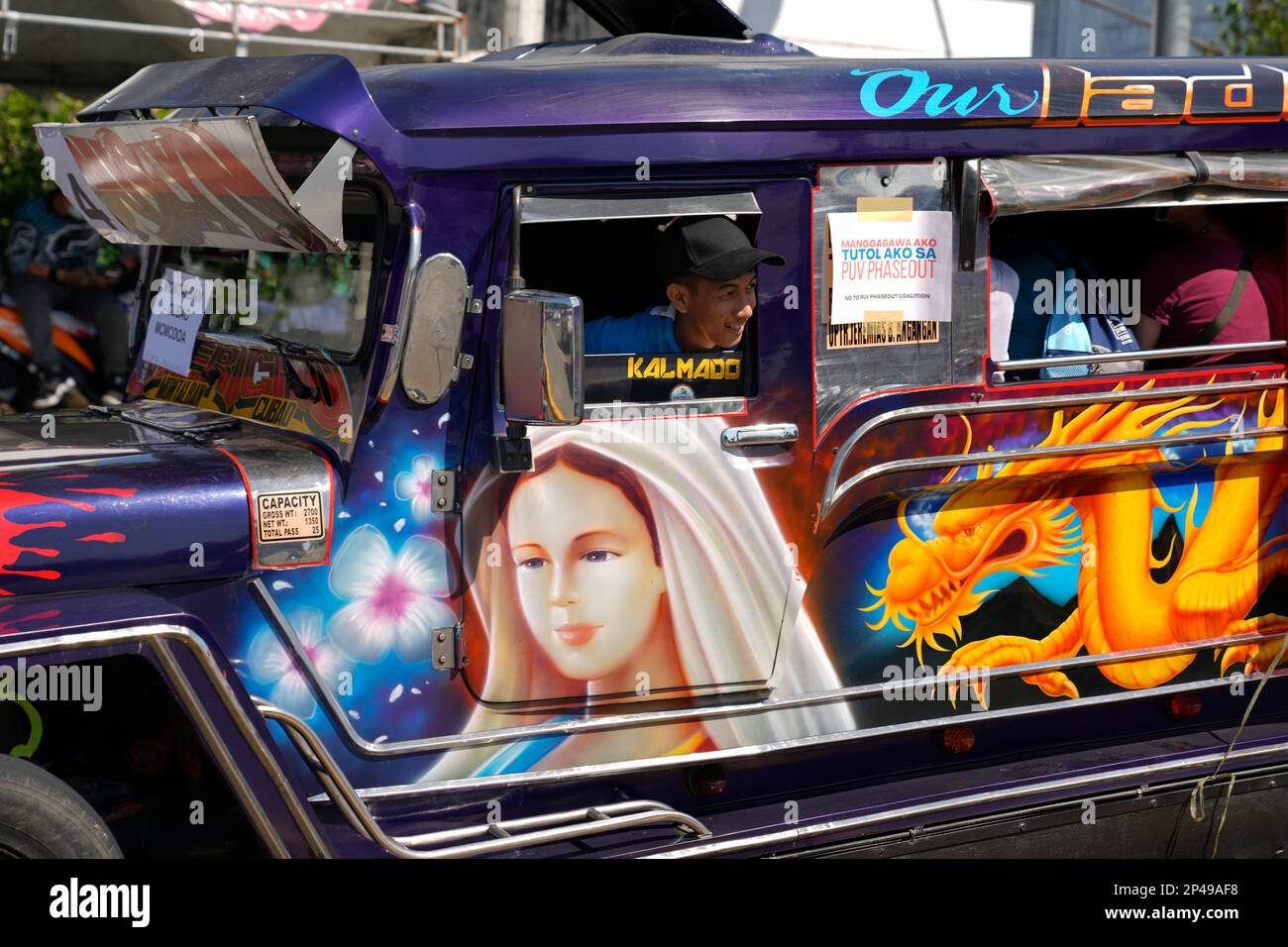 A driver looks out from his passenger jeepney as he joins a rally ...