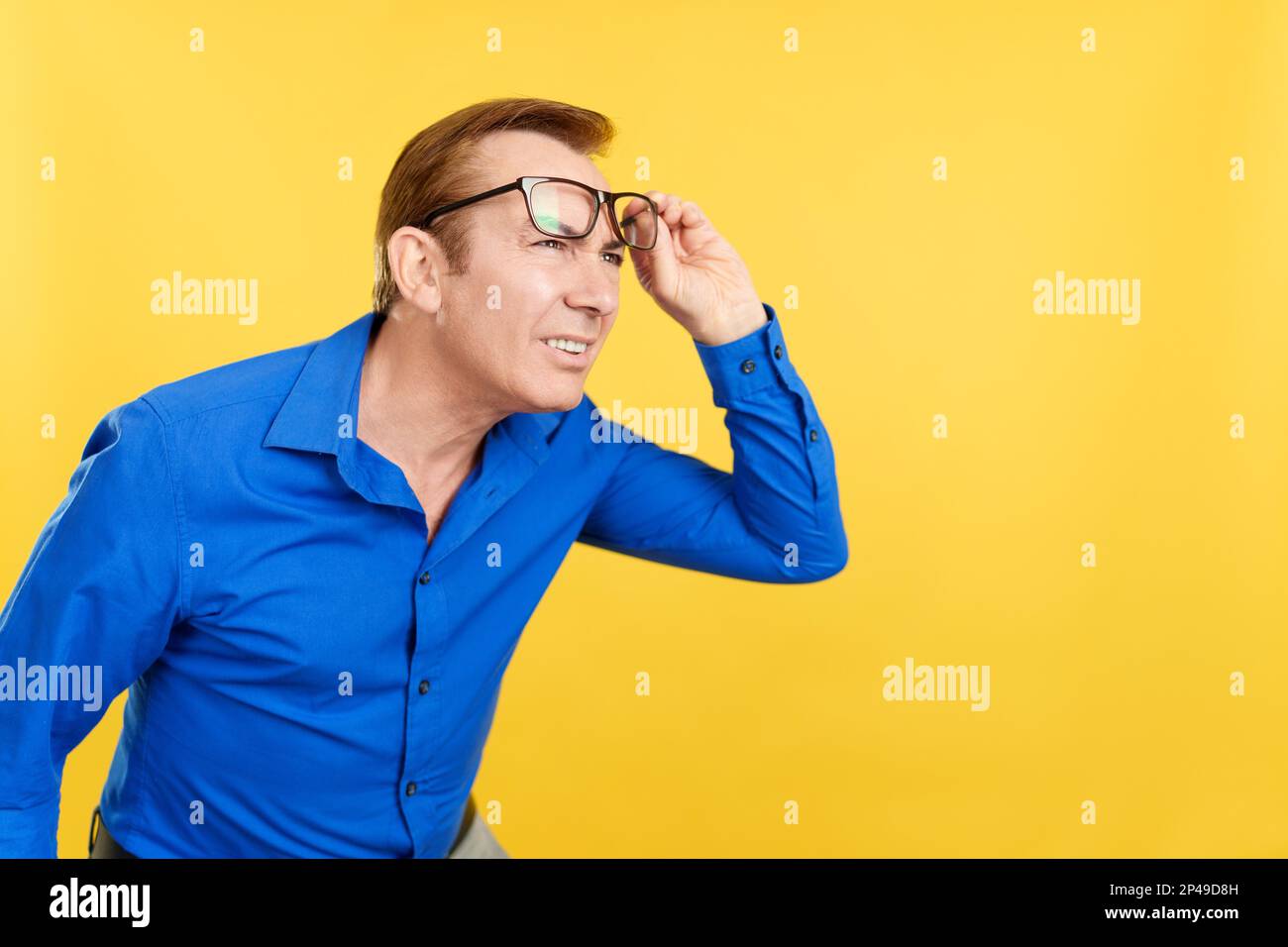 Mature man taking off her glasses to see far away Stock Photo - Alamy