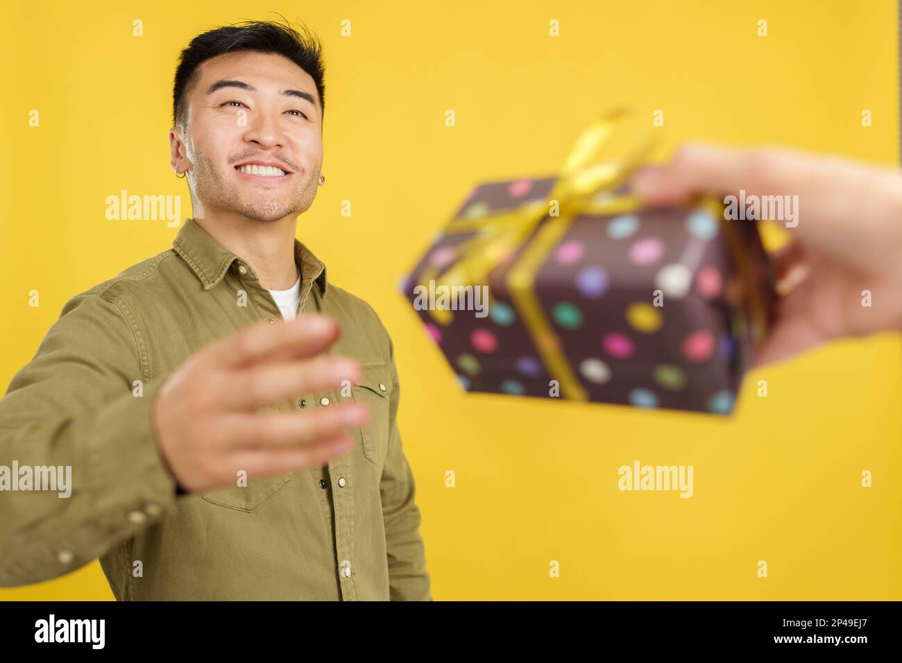 Happy chinese man smiling while receiving a gift Stock Photo - Alamy