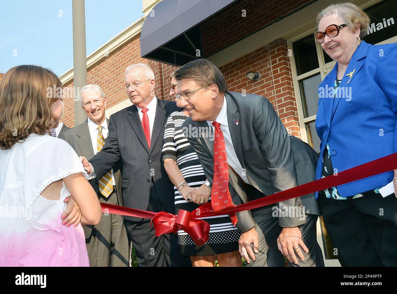 North Carolina Governor Pat McCrory, second from right, leans over to ...