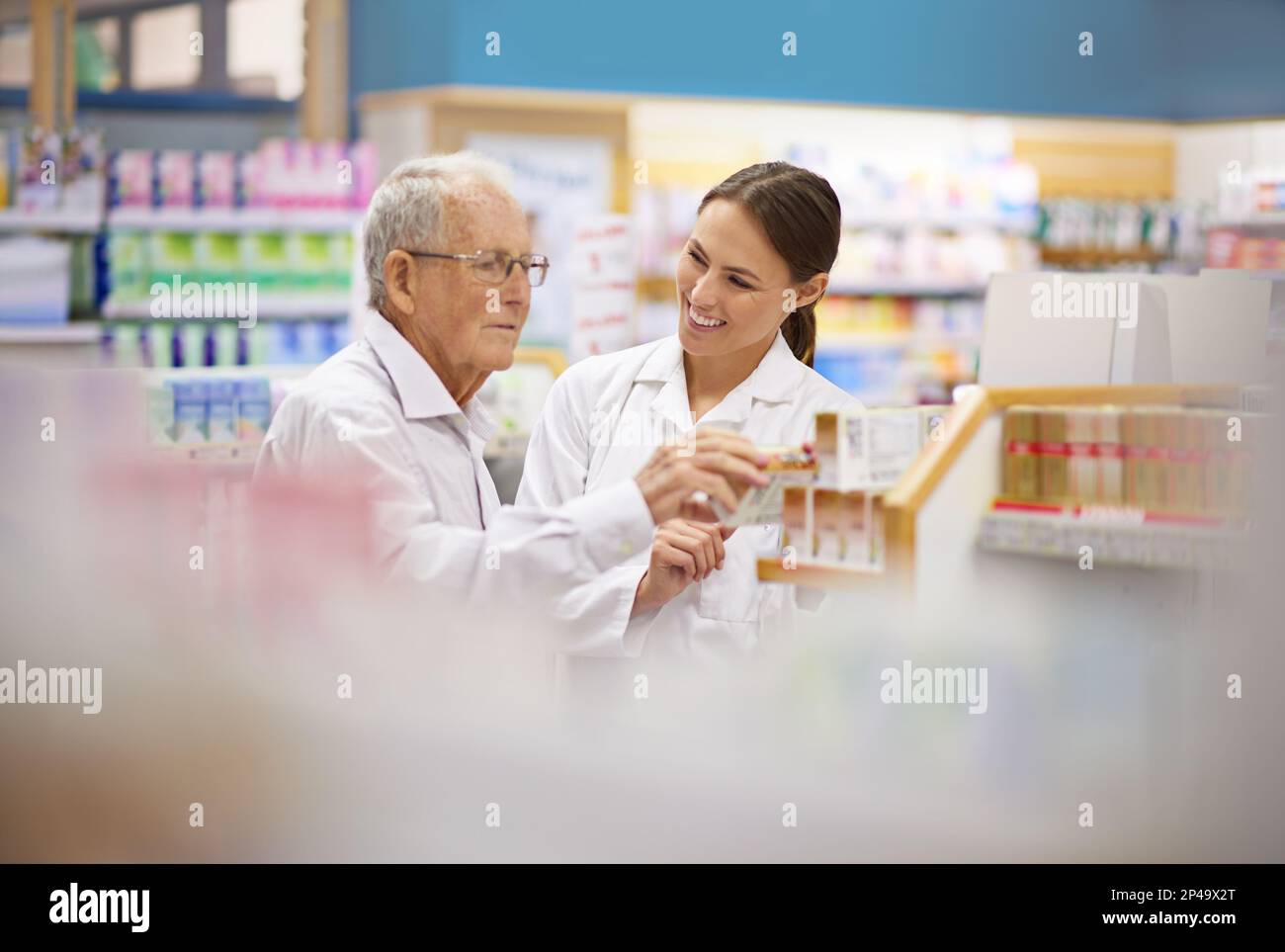 Making sure her customers are taken care of. a young pharmacist helping ...