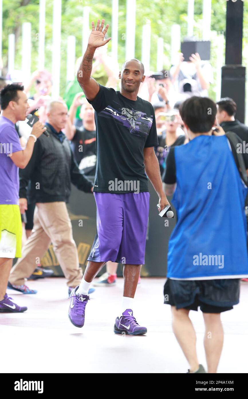 NBA superstar Kobe Bryant, center, waves to fans at a fan meeting ...