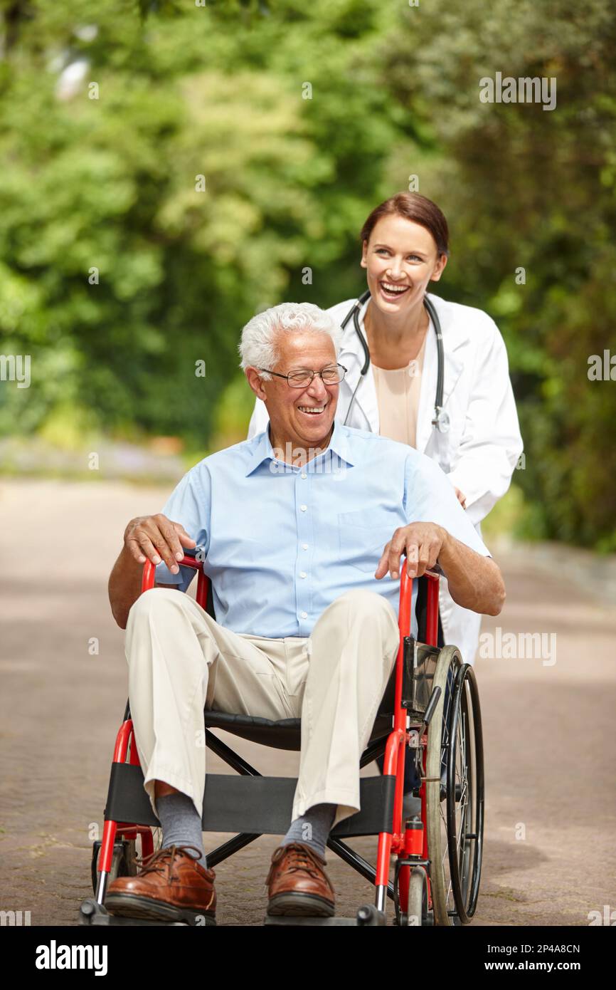 Nature therapy. a female doctor taking her senior patient for an outing ...