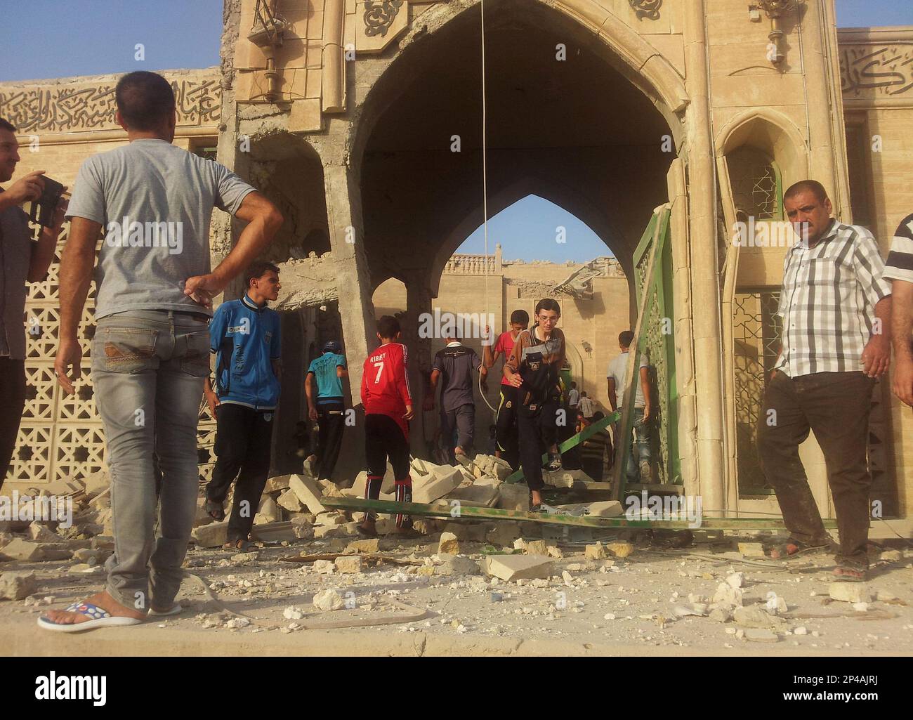 People inspect the destroyed Mosque of The Prophet Younis, or Jonah, in ...
