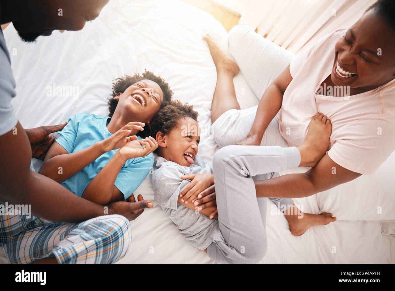 Tickle, laugh and relax with black family in bedroom for bonding ...